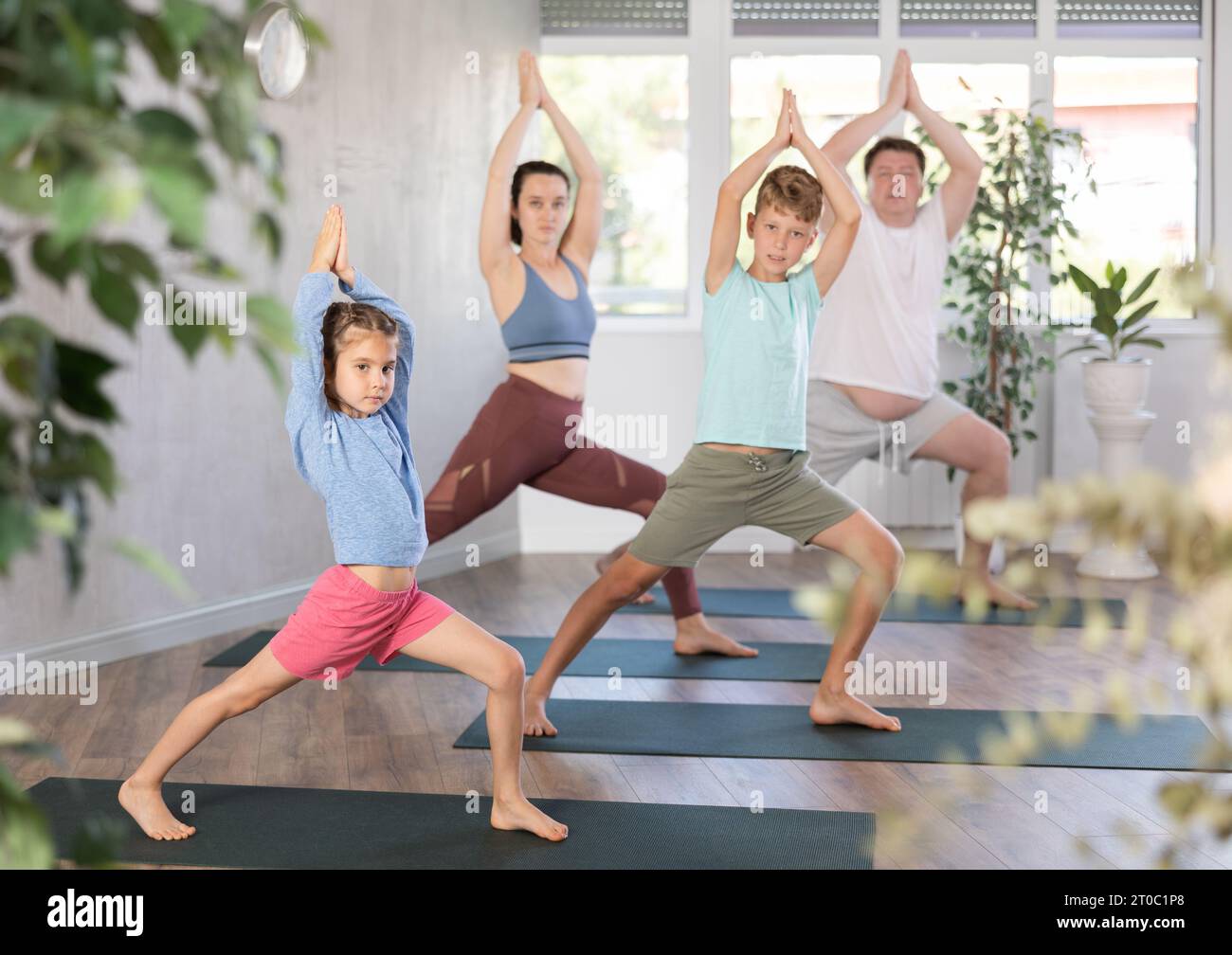 Family with children practicing various yoga positions during training ...