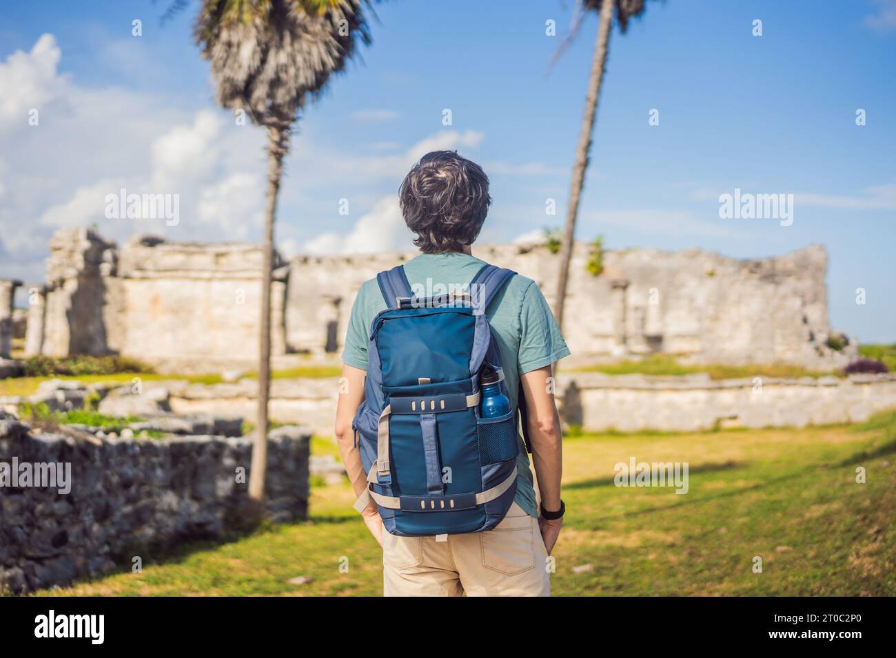 Male tourist enjoying the view Pre-Columbian Mayan walled city of Tulum ...