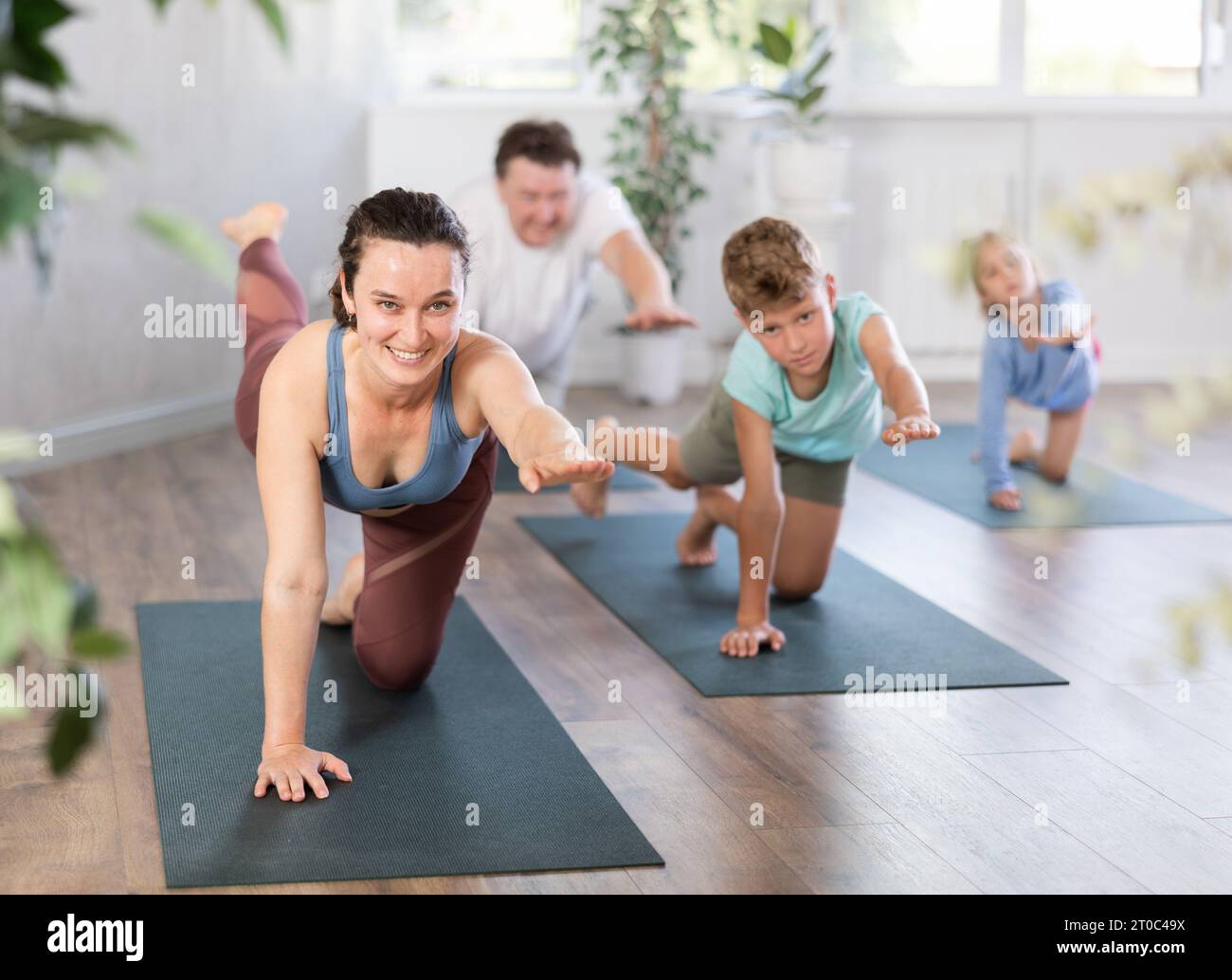 Family with two children doing yoga in studio Stock Photo - Alamy