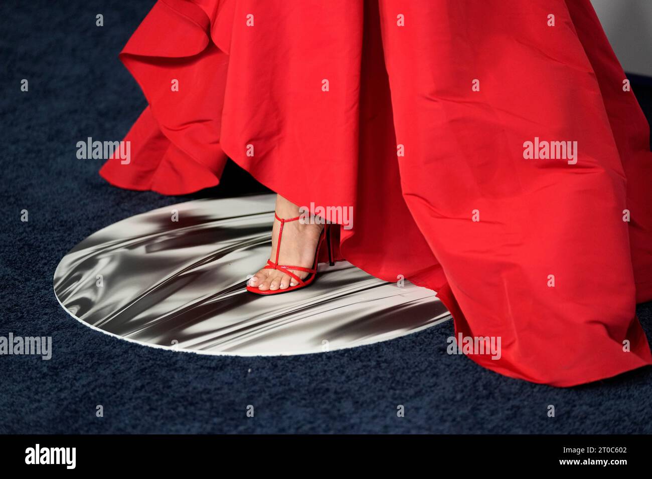 A shoe peeks out from below her dress as Telemundo news anchor Johana ...