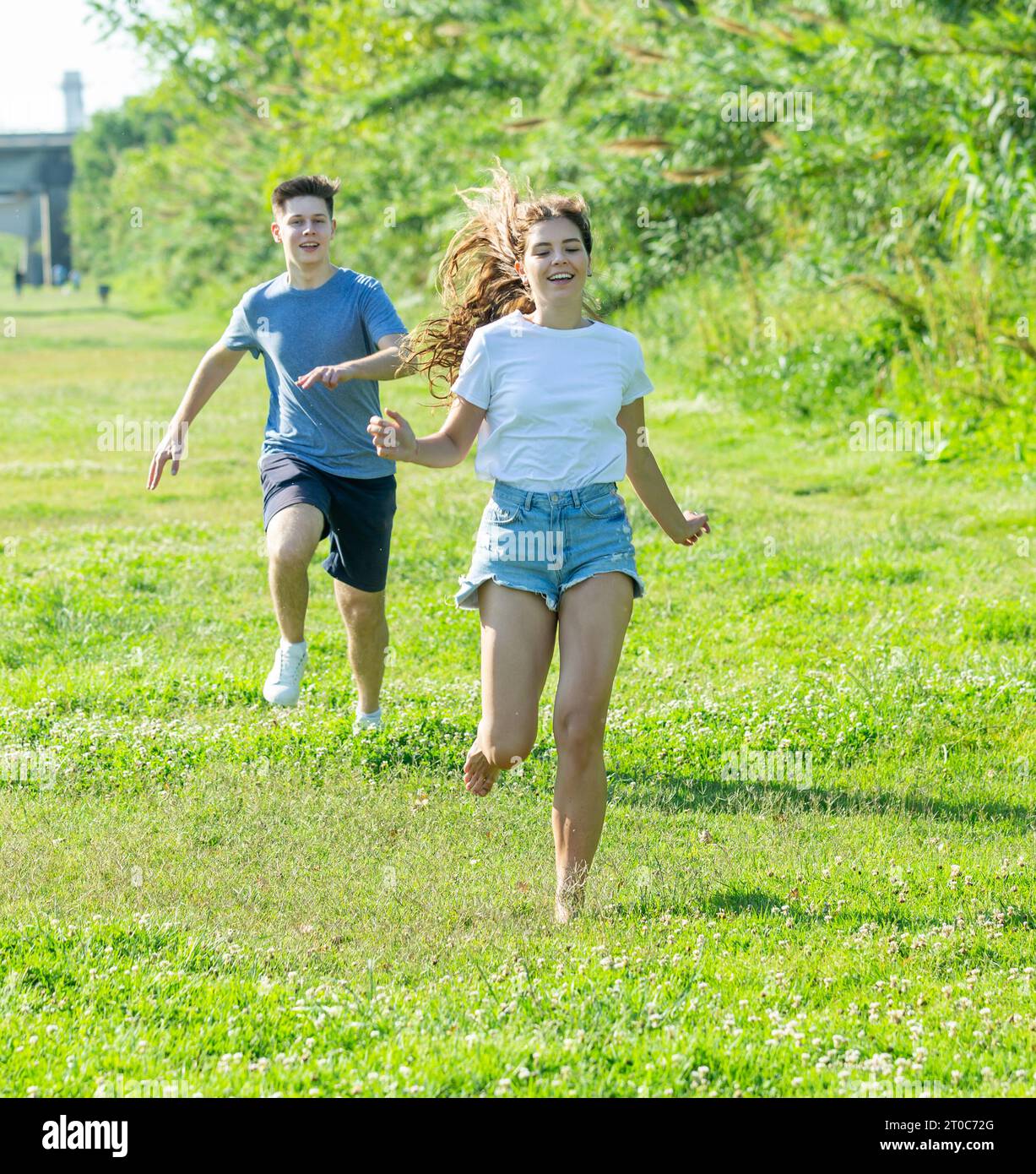 Two teenagers are running on the grass Stock Photo - Alamy