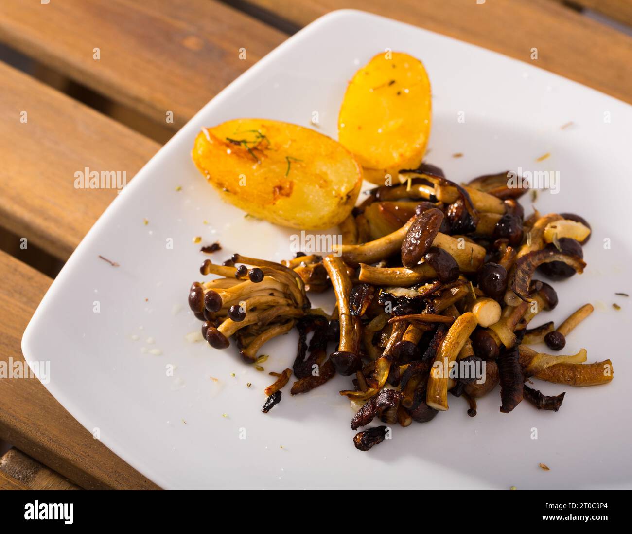 Delicious cooked fried honey fungus mushrooms with young potatoes Stock ...