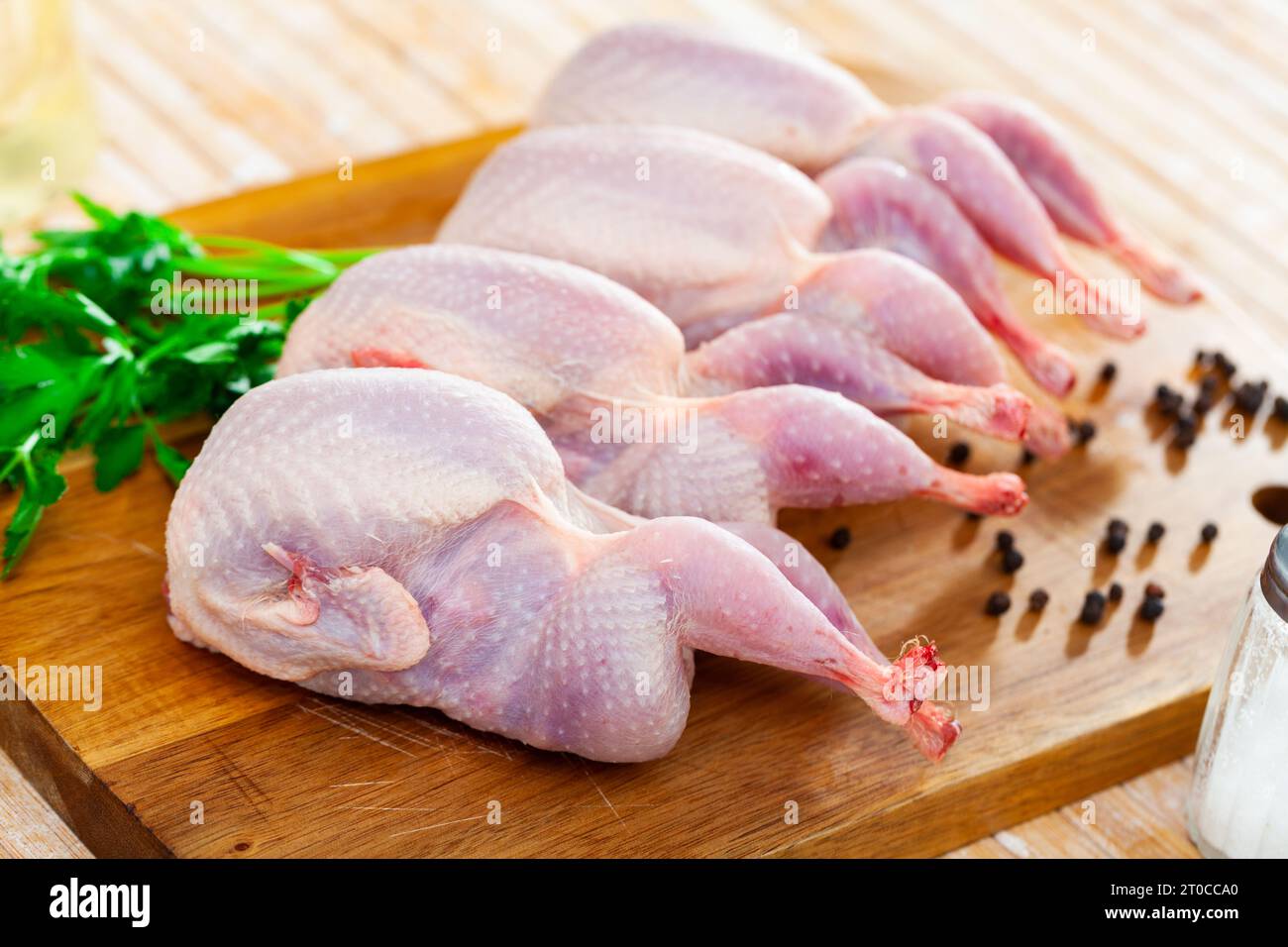 Quail carcasses lie on cutting board. Small birds are prepared for ...