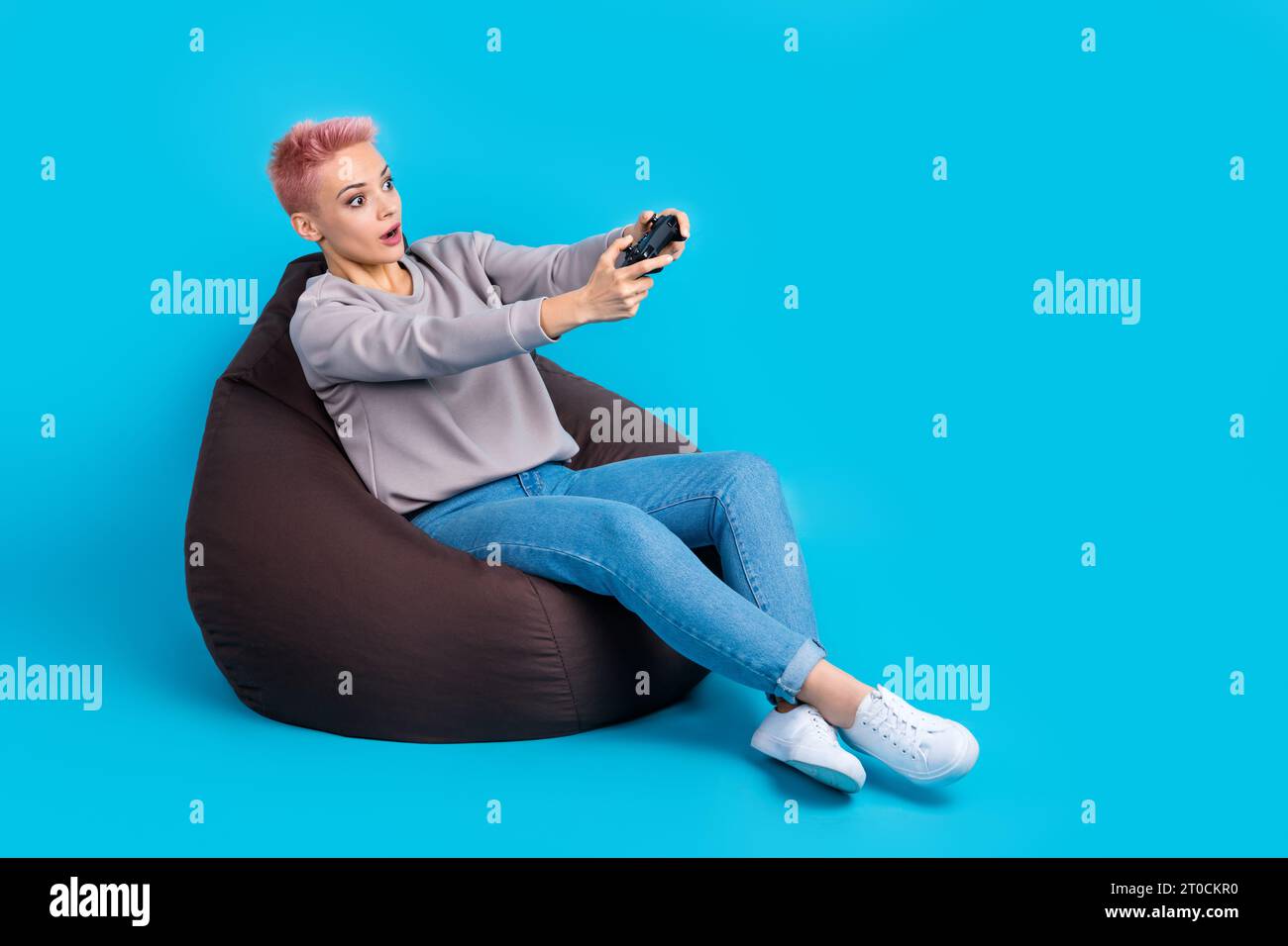 Full body profile photo of impressed gamer girl sit cozy bag hands hold ...