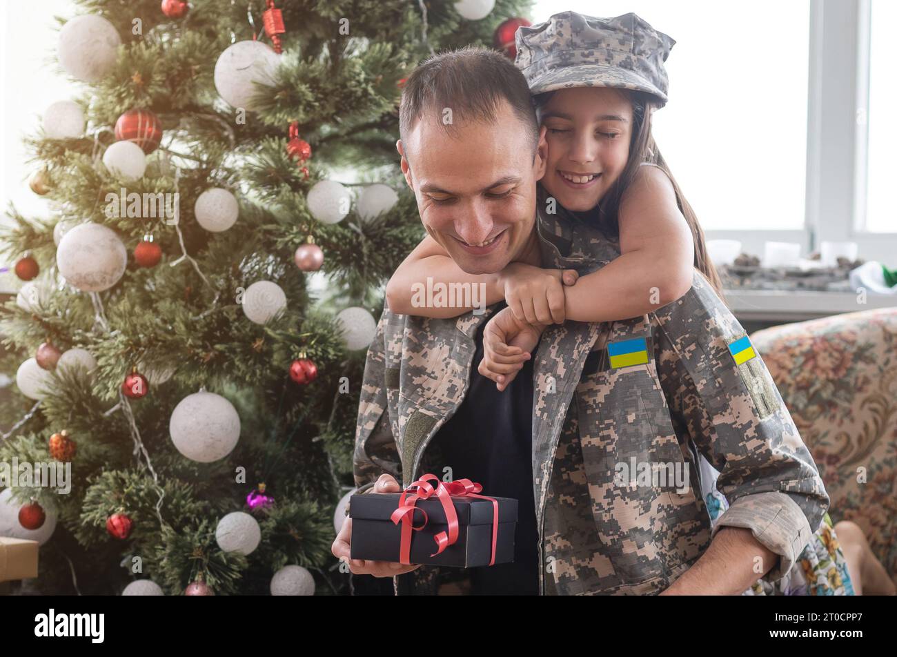 Father in Ukrainian military uniform and his daughter. Family reunion ...