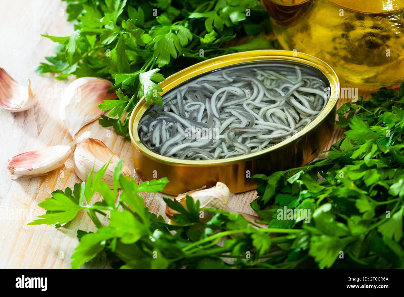 Pickled eels on background with garlic and greens at table Stock Photo ...
