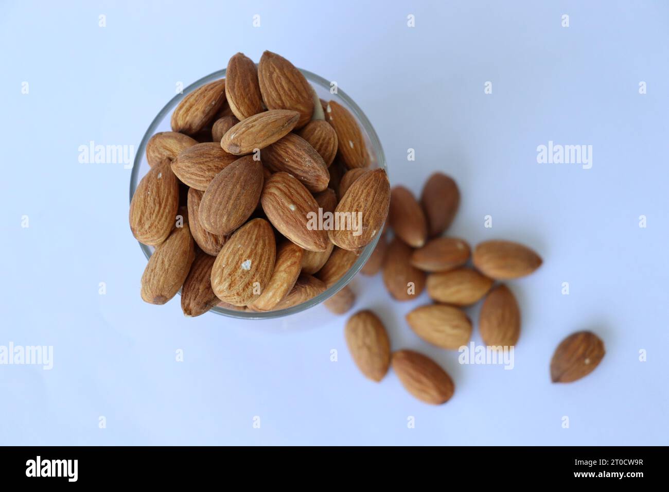 a large number of natural dried almond kernels in a glass container on ...