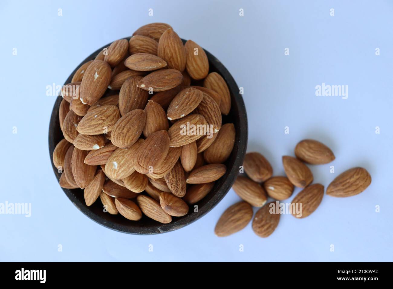 a large number of natural dried almond kernels in a wooden container ...