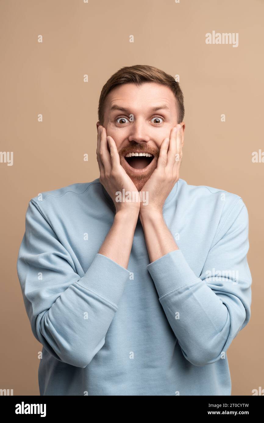 Happy surprised man looking at camera smiling with opened mouth wide ...