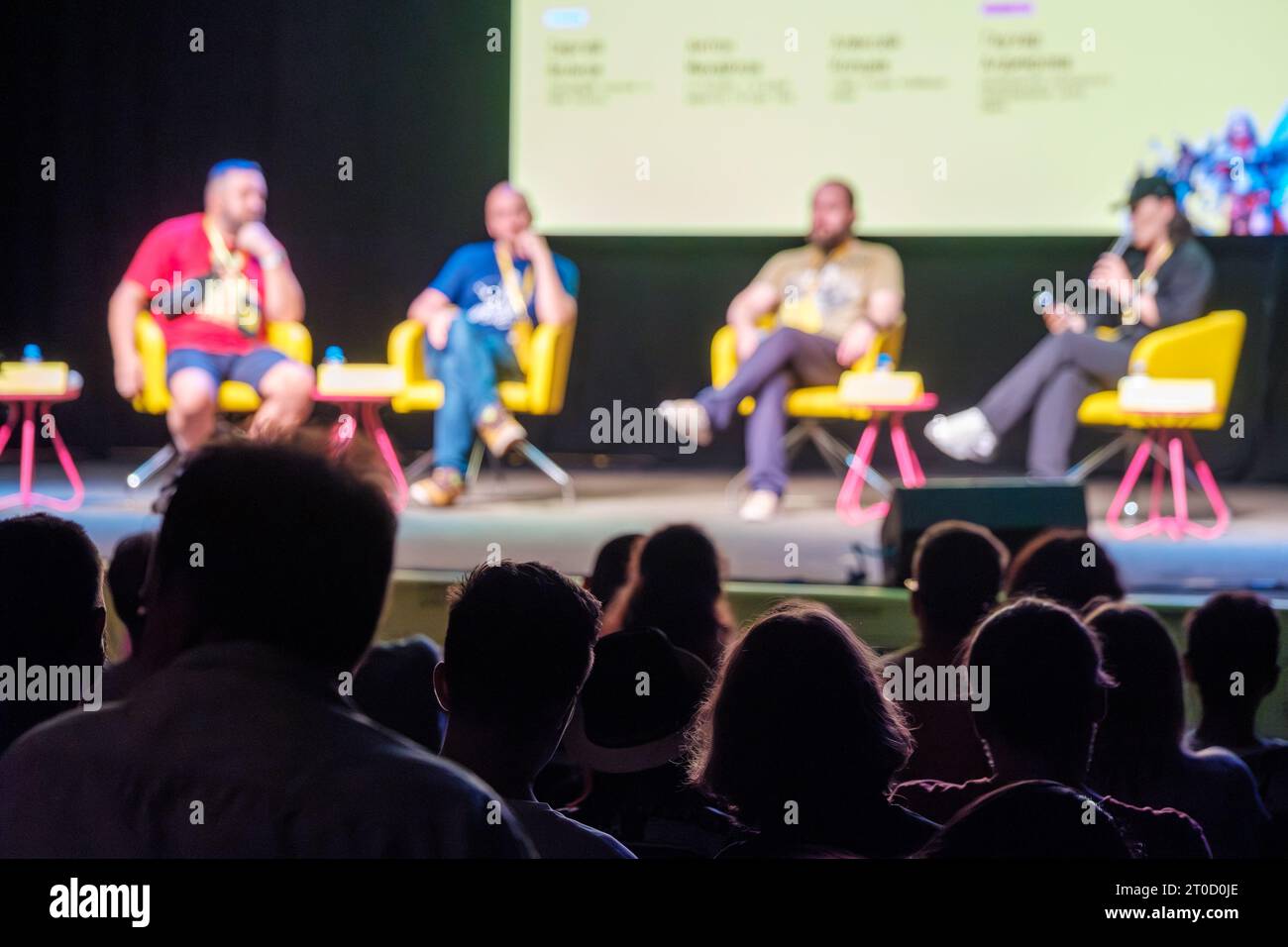 Colleagues sitting on stage during conference answering questions from ...