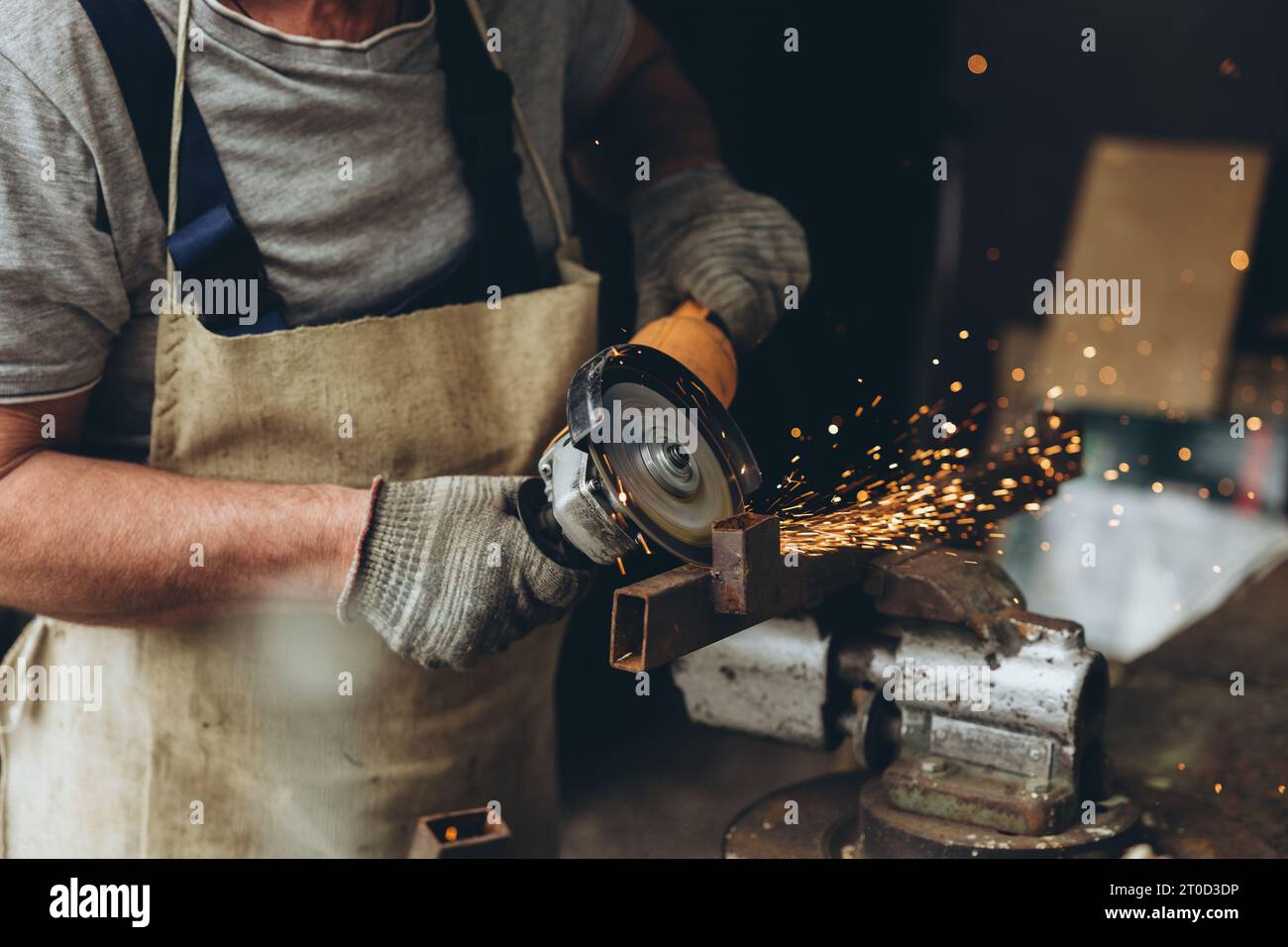 The man uses a metal cutting tool in the workshop Stock Photo - Alamy