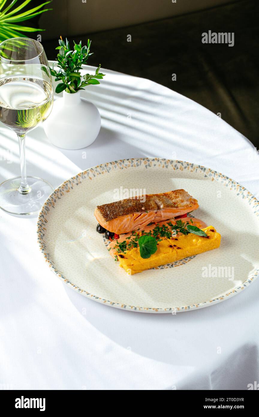 grilled salmon with a side dish of corn puree and sauce Stock Photo - Alamy