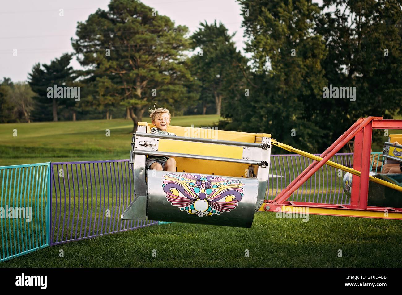 Happy child riding carnival ride at county fair Stock Photo - Alamy
