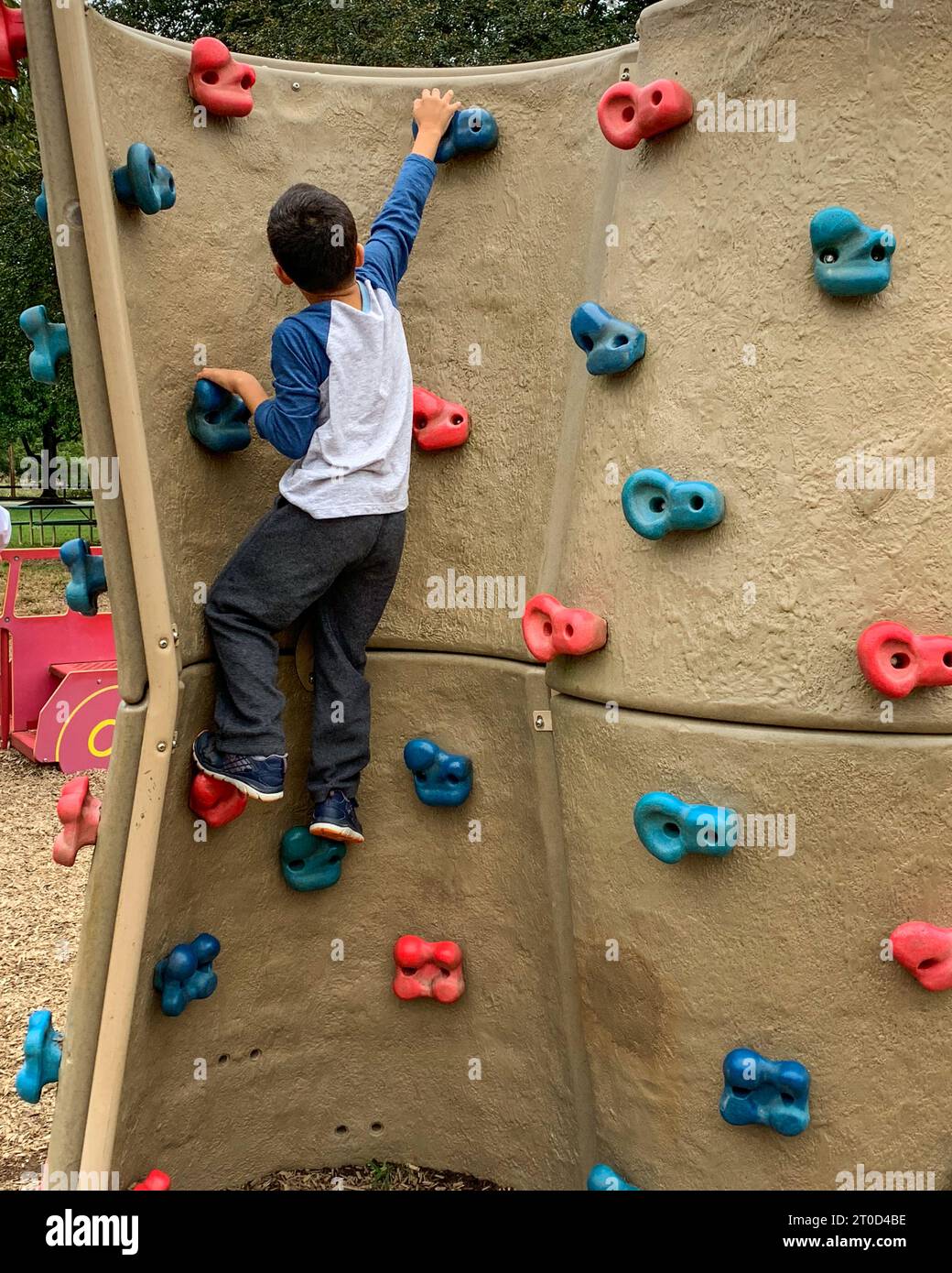 Young boy playing on climbing wall suburban playground Stock Photo - Alamy