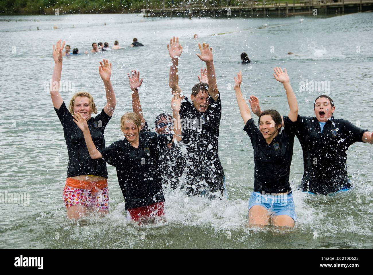 Secondary school pupils splashing in the water, in the lake, on an ...