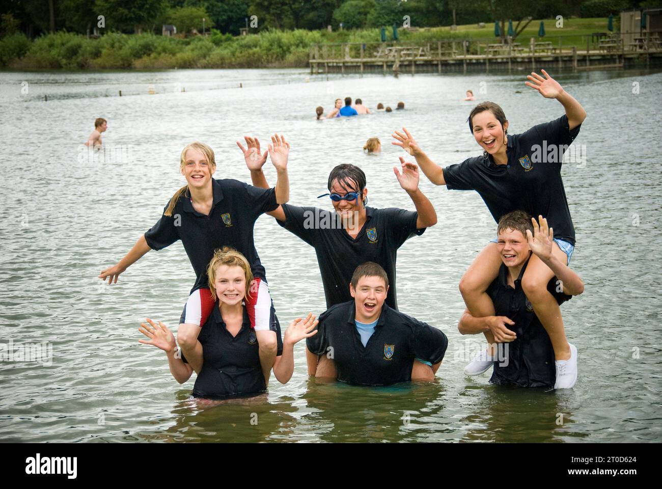 Secondary school pupils splashing in the water, in the lake, on an ...