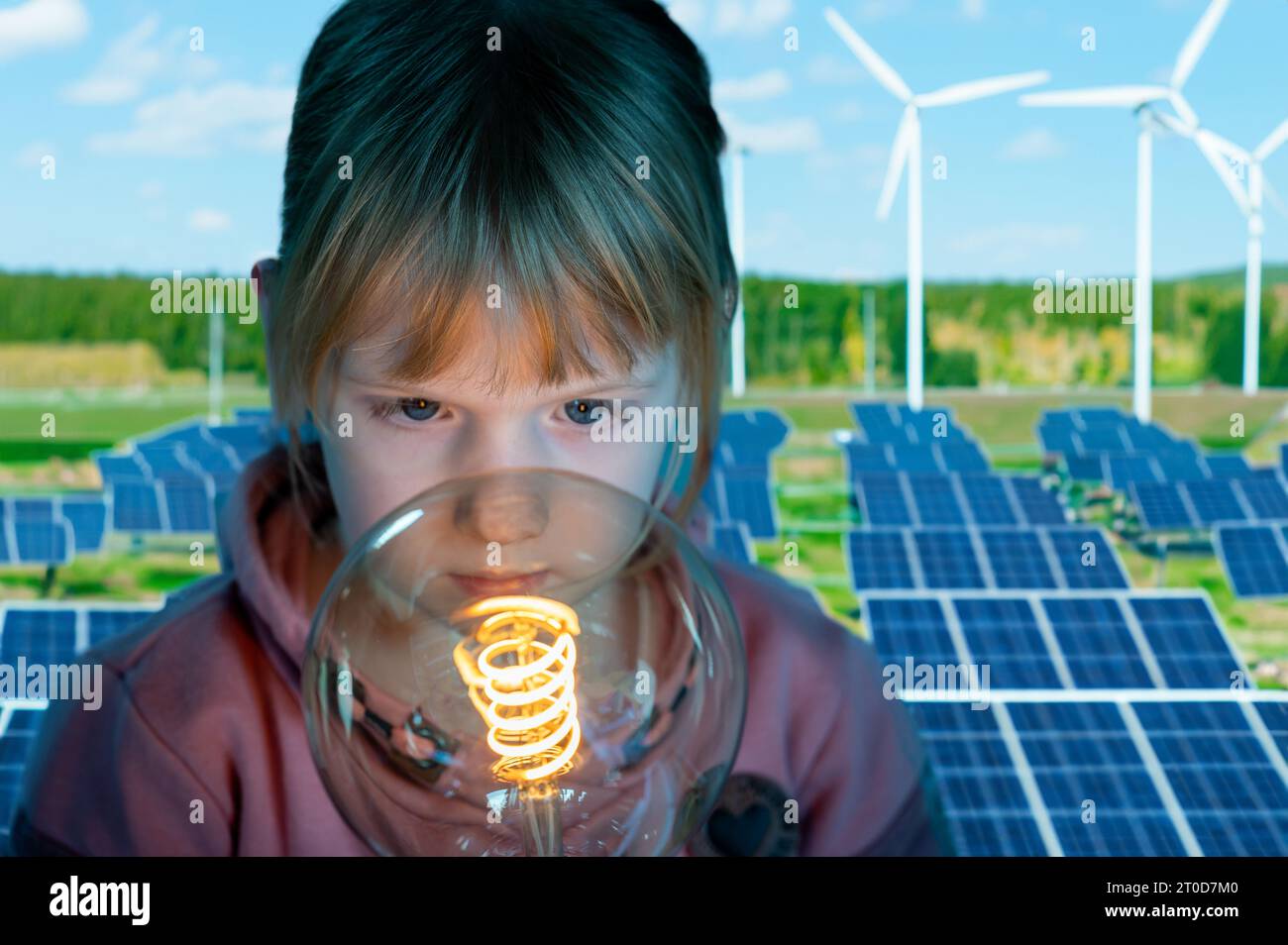 Symbol for using renewable energy. Child looks to a light bulb in front ...