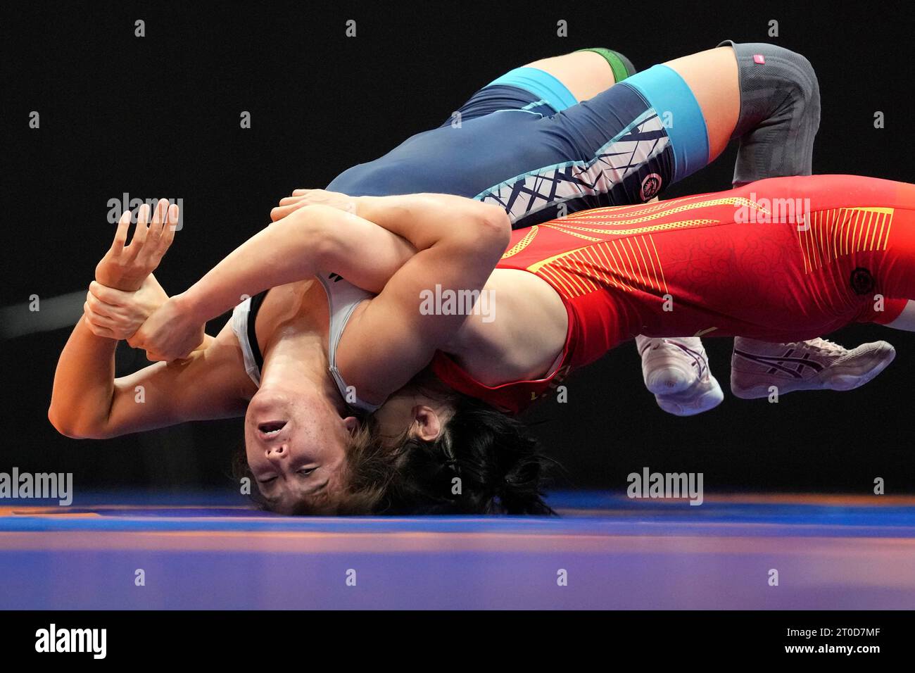 China's Zhou Feng, bottom, and Kyrgyztan's Nurzal Nurtaeva compete ...