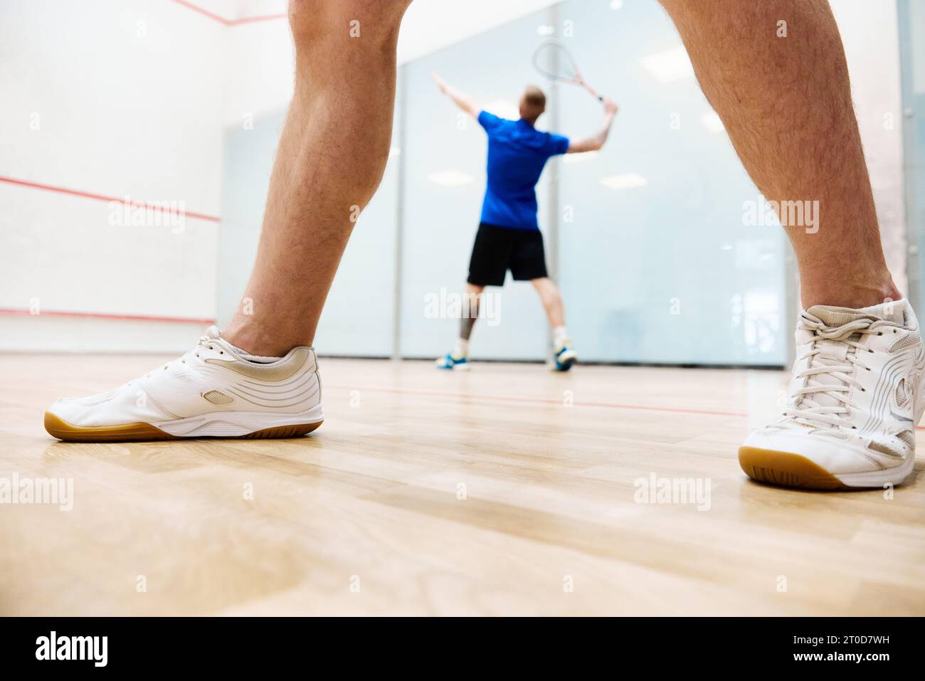 Young sportive men, friends playing squash together on squash court ...