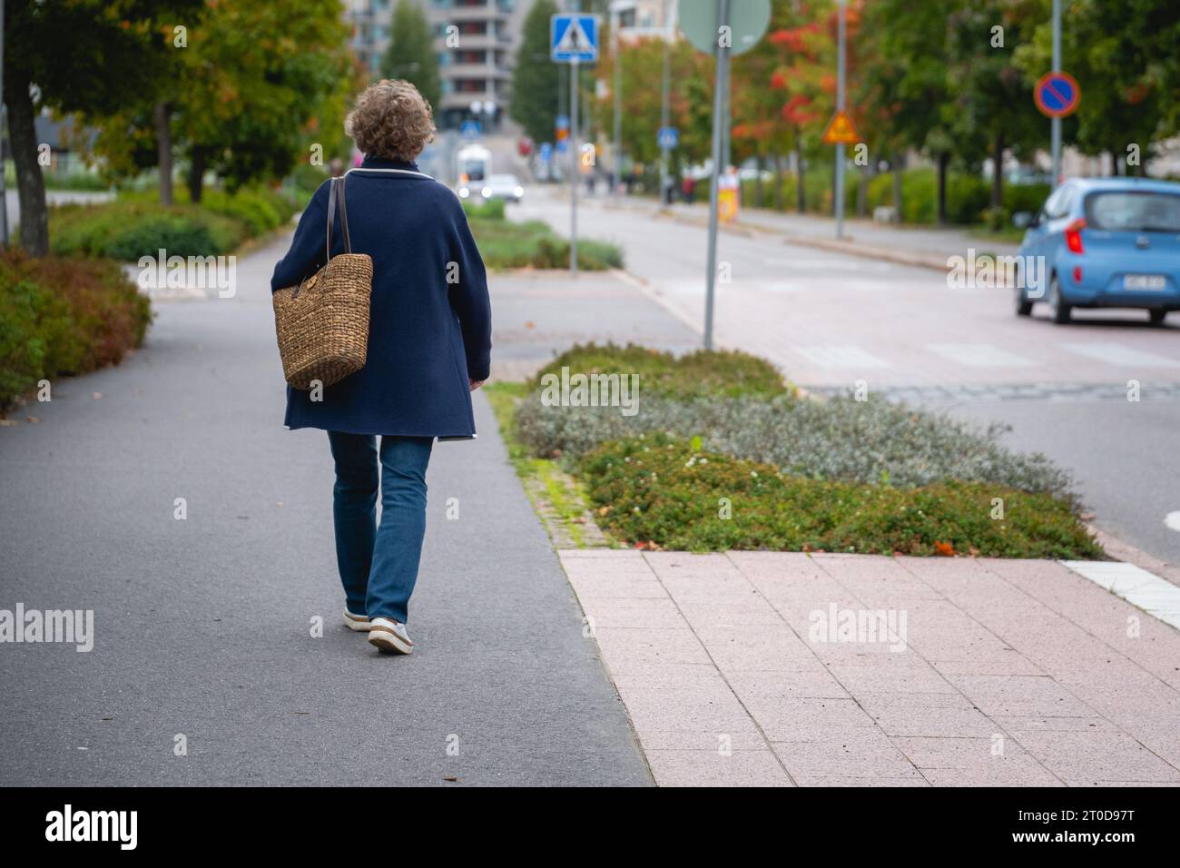 woman walking on a street alone on city streets Stock Photo - Alamy