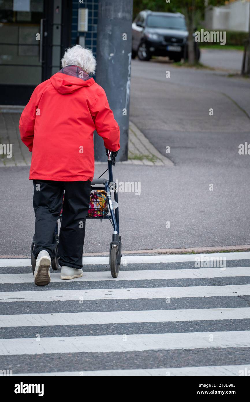 an elder woman walking with a rollator at city streets Stock Photo - Alamy