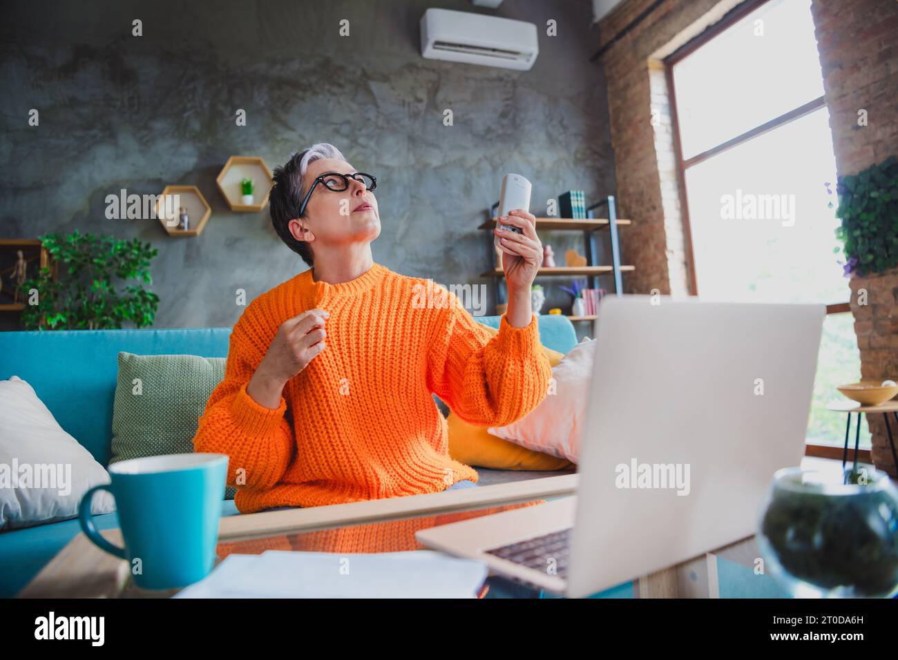 Photo of suffering heat elderly lady wear orange pullover turning on ...