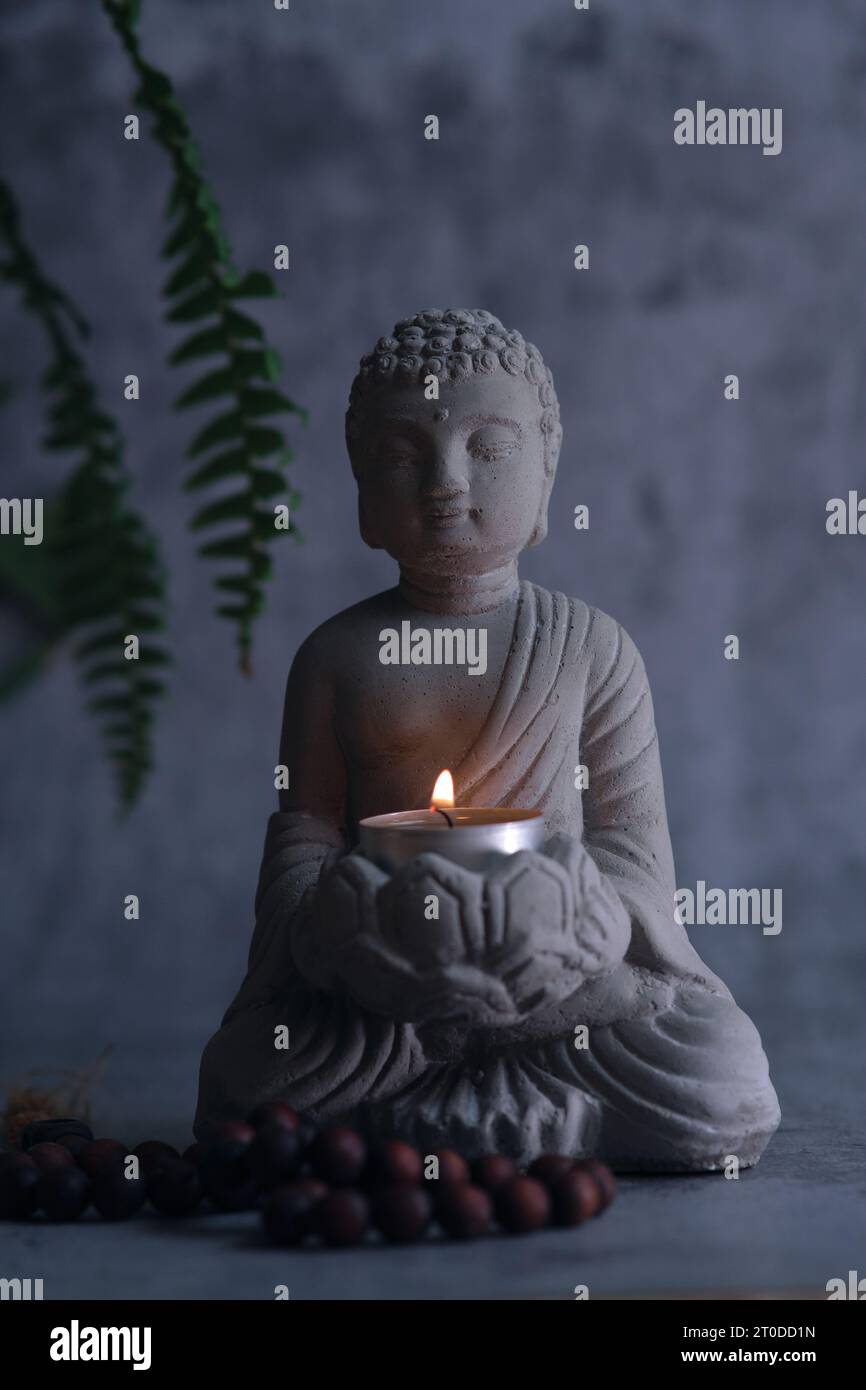 a small stone statue of Buddha Stock Photo - Alamy