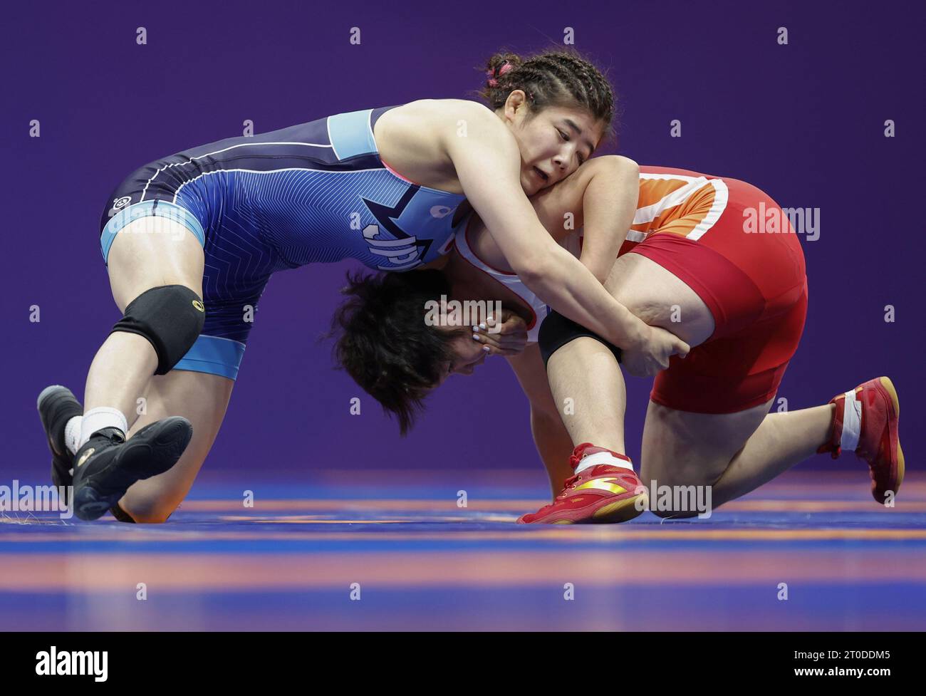 Japanese wrestler Nonoka Ozaki (blue) competes against Mun Hyong Yong ...