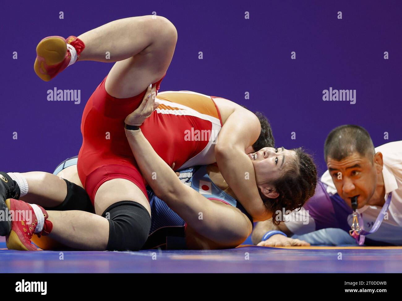 Japanese wrestler Nonoka Ozaki (blue) competes against Mun Hyong Yong ...