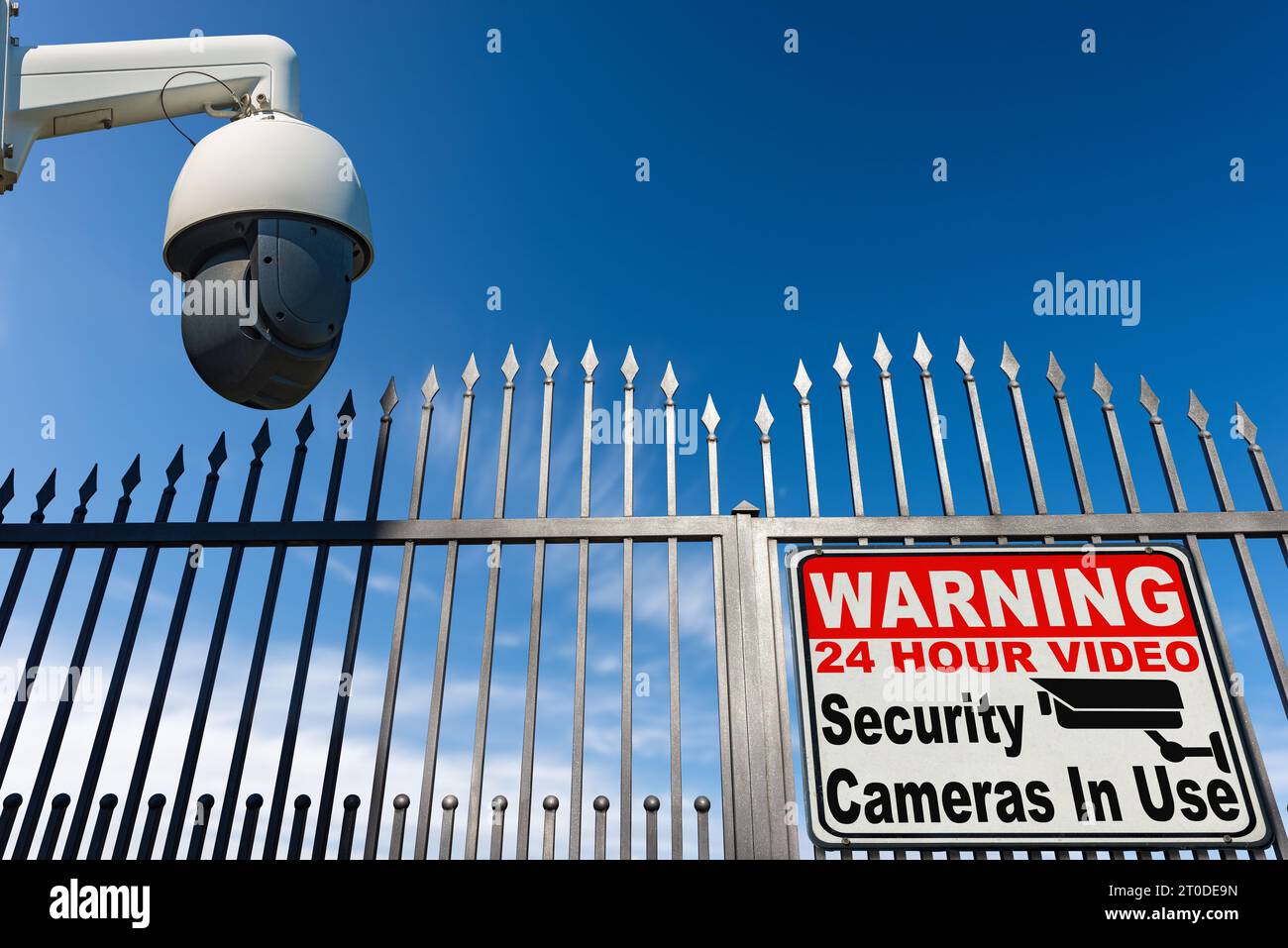 Modern security camera monitoring the entrance to a gate of a private ...