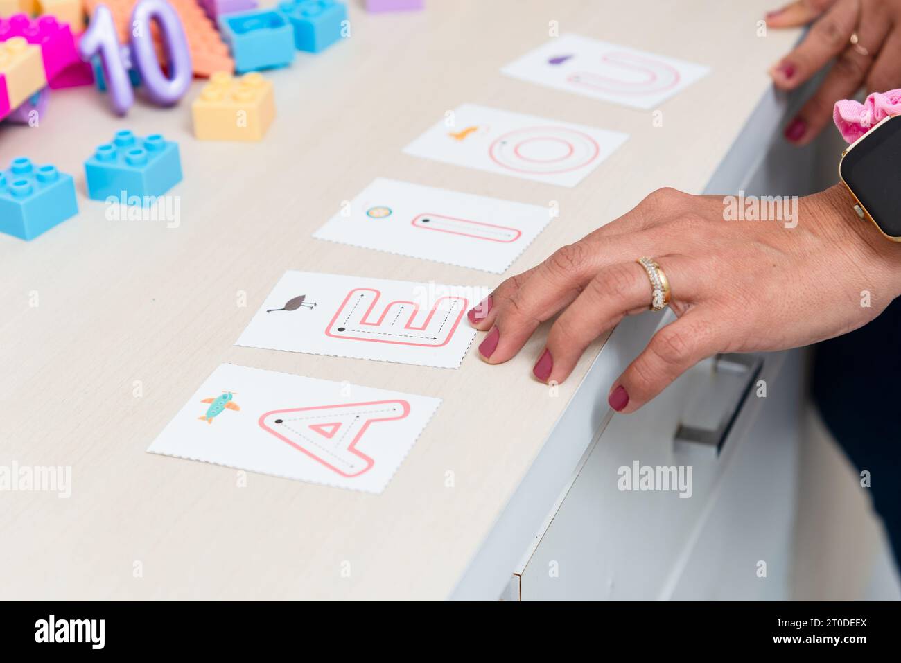 Hand of a psychopedagogue showing letters with letters of the alphabet ...