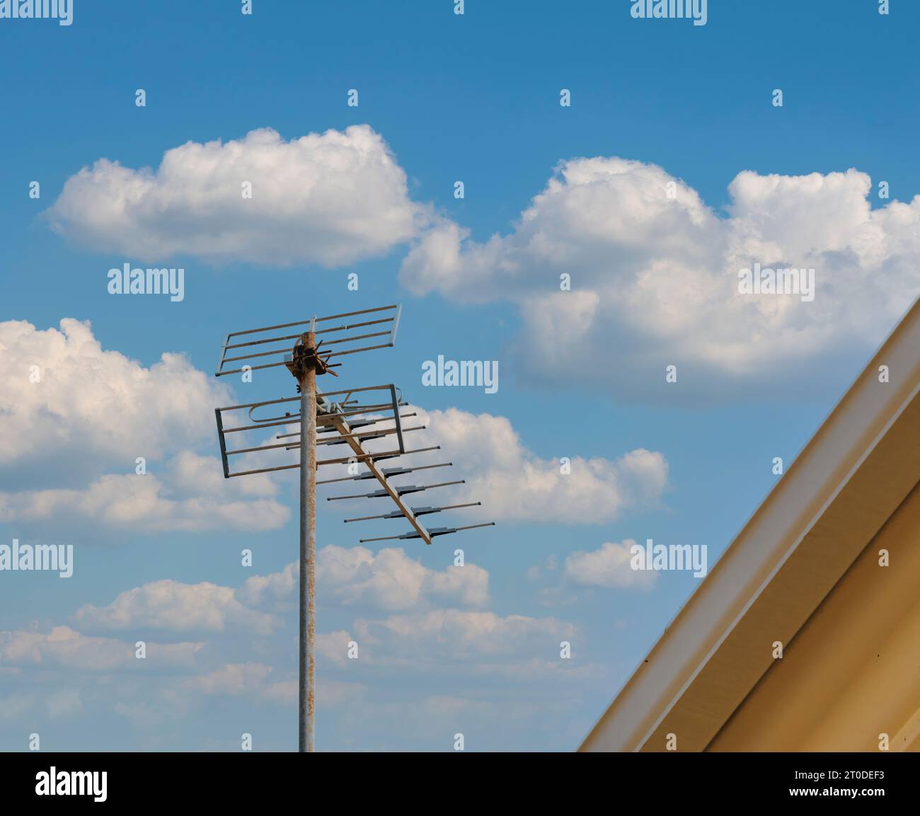 A large aerial antenna prominently stands atop a building, set against ...