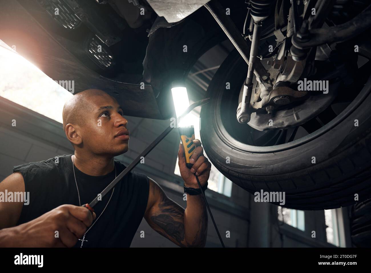 Concentrated car mechanic checking condition of wheels and axle Stock ...