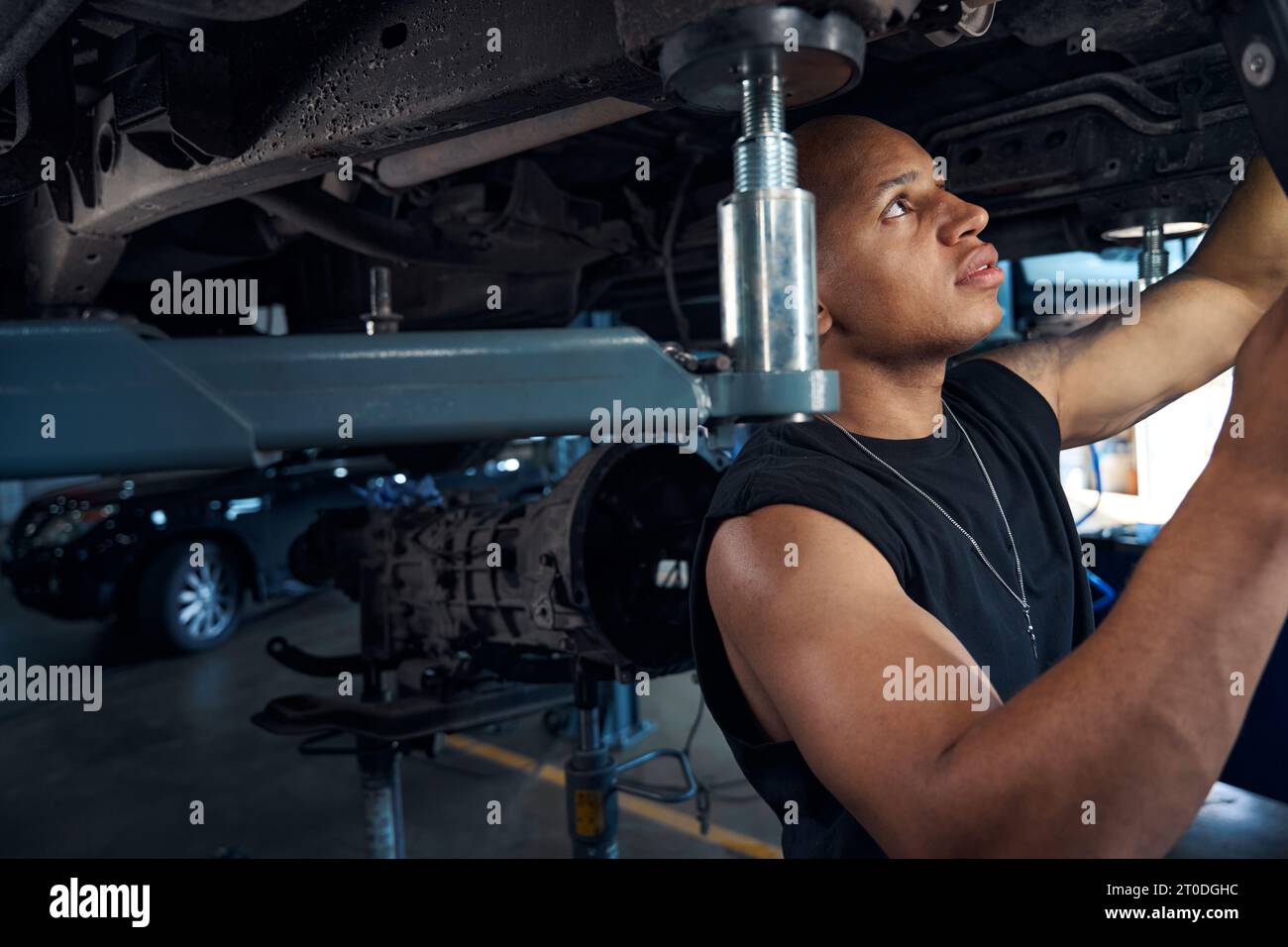 Auto-mechanic checking car-lift before lifting automobiles for ...