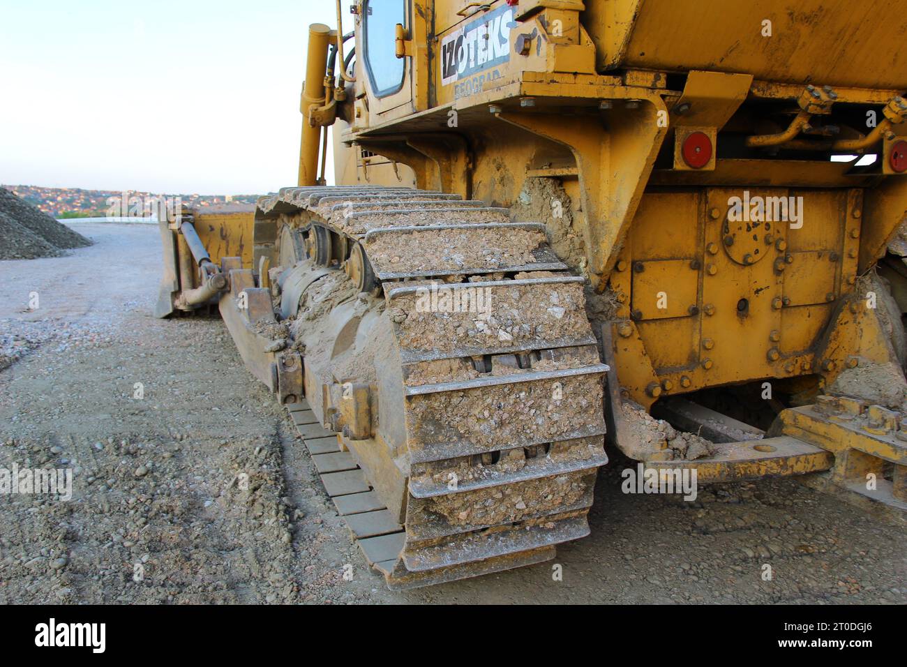 On a sunny day, a powerful yellow bulldozer roars across the terrain ...