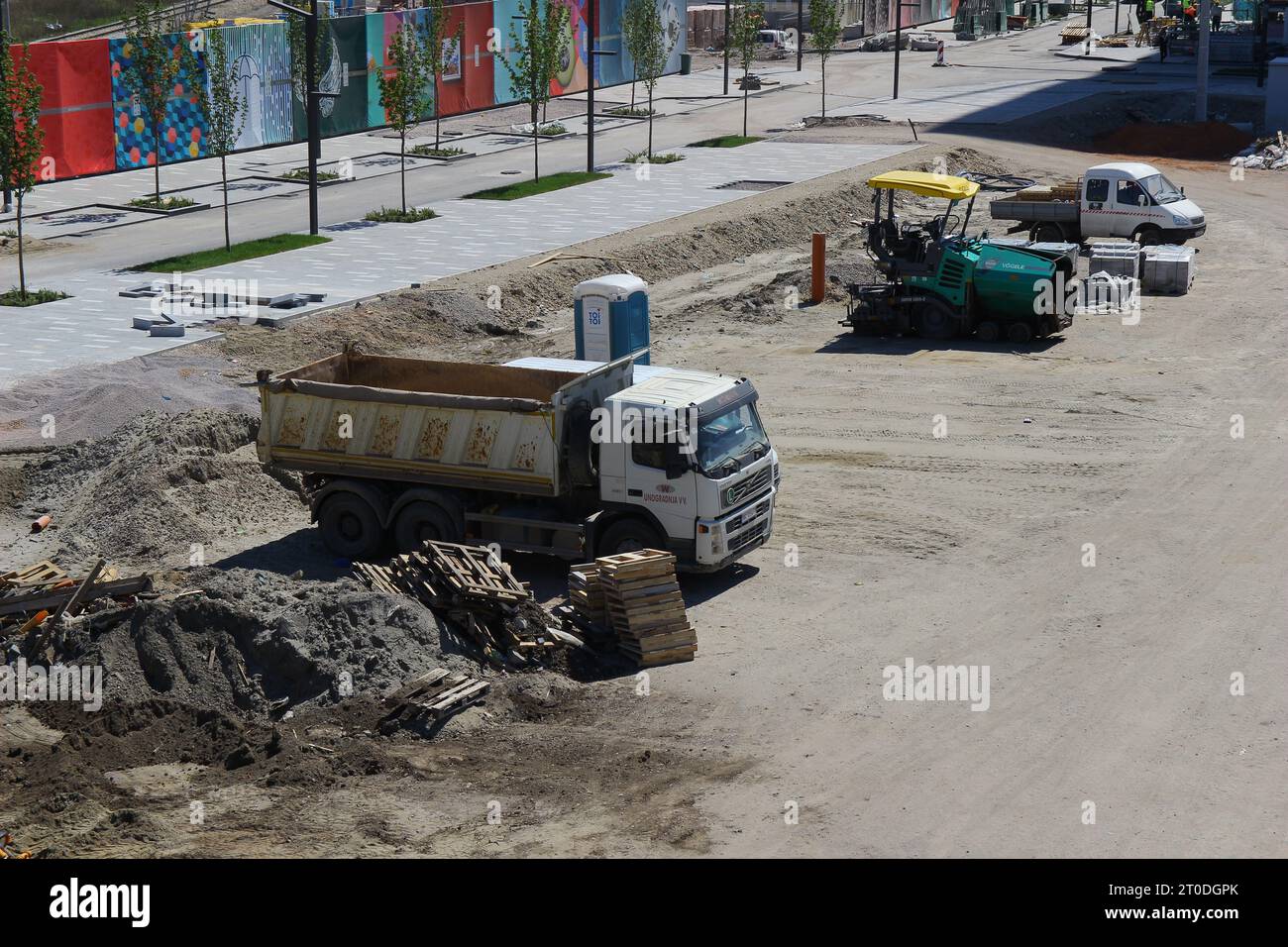 The outdoor construction site hums with the rumble of heavy machinery ...