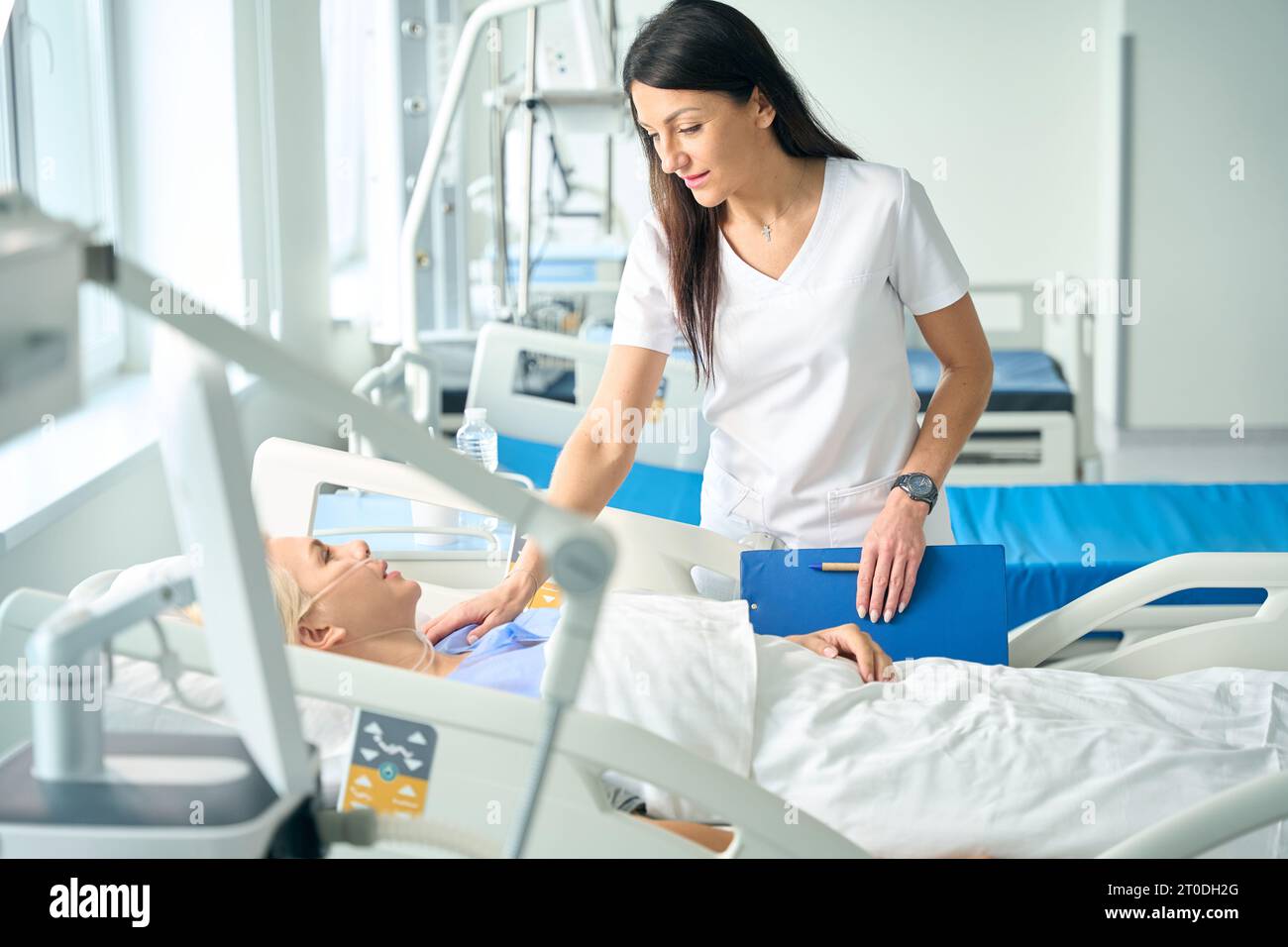Caring female doctor encourages a lady after an operation Stock Photo ...