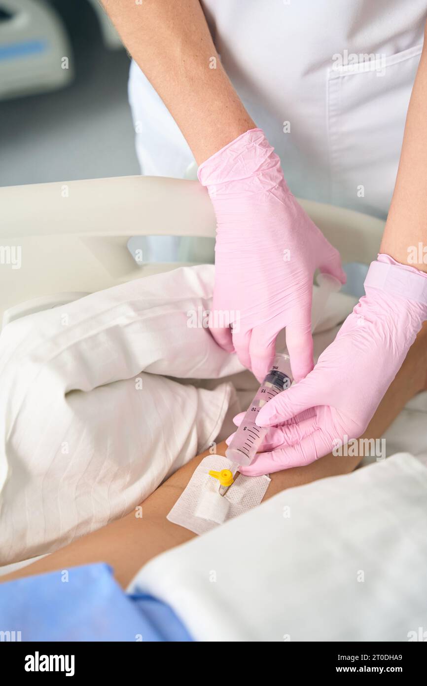 Nurse makes an injection into patients vein with large syringe Stock ...