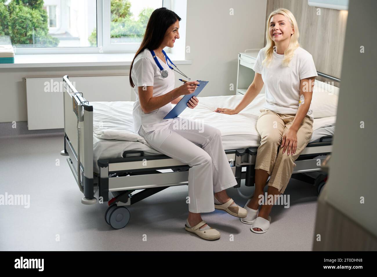 Attending physician communicates with a patient in a hospital ward ...