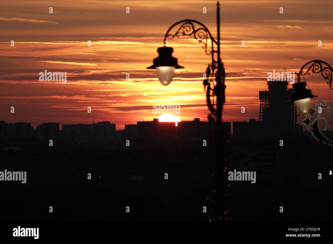 The warm evening sky was lit up with a soft backlighting, as the city ...