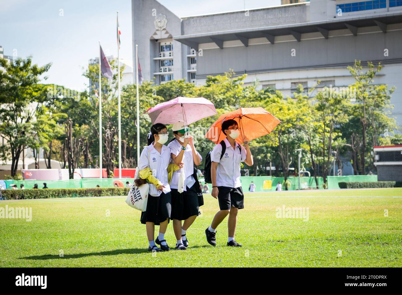 Thai university students wander across the main lawn of ...