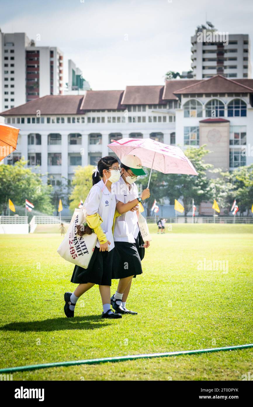 Thai university students wander across the main lawn of ...