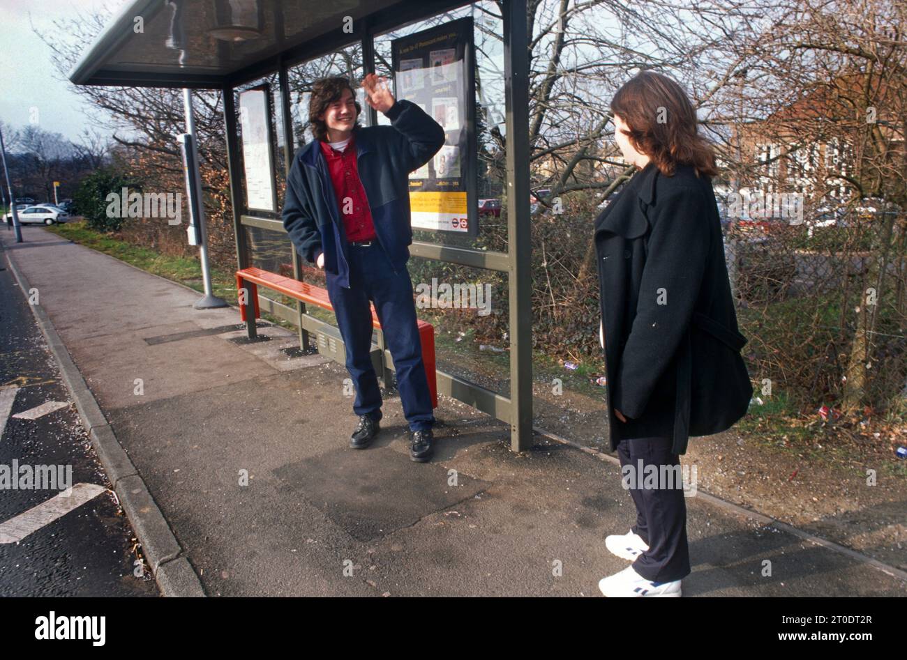 Teenage Boy Waving to Girl at Bus Stop Surrey England Stock Photo - Alamy