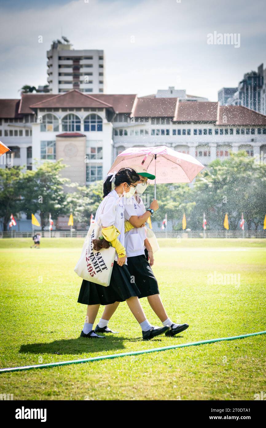Thai university students wander across the main lawn of ...