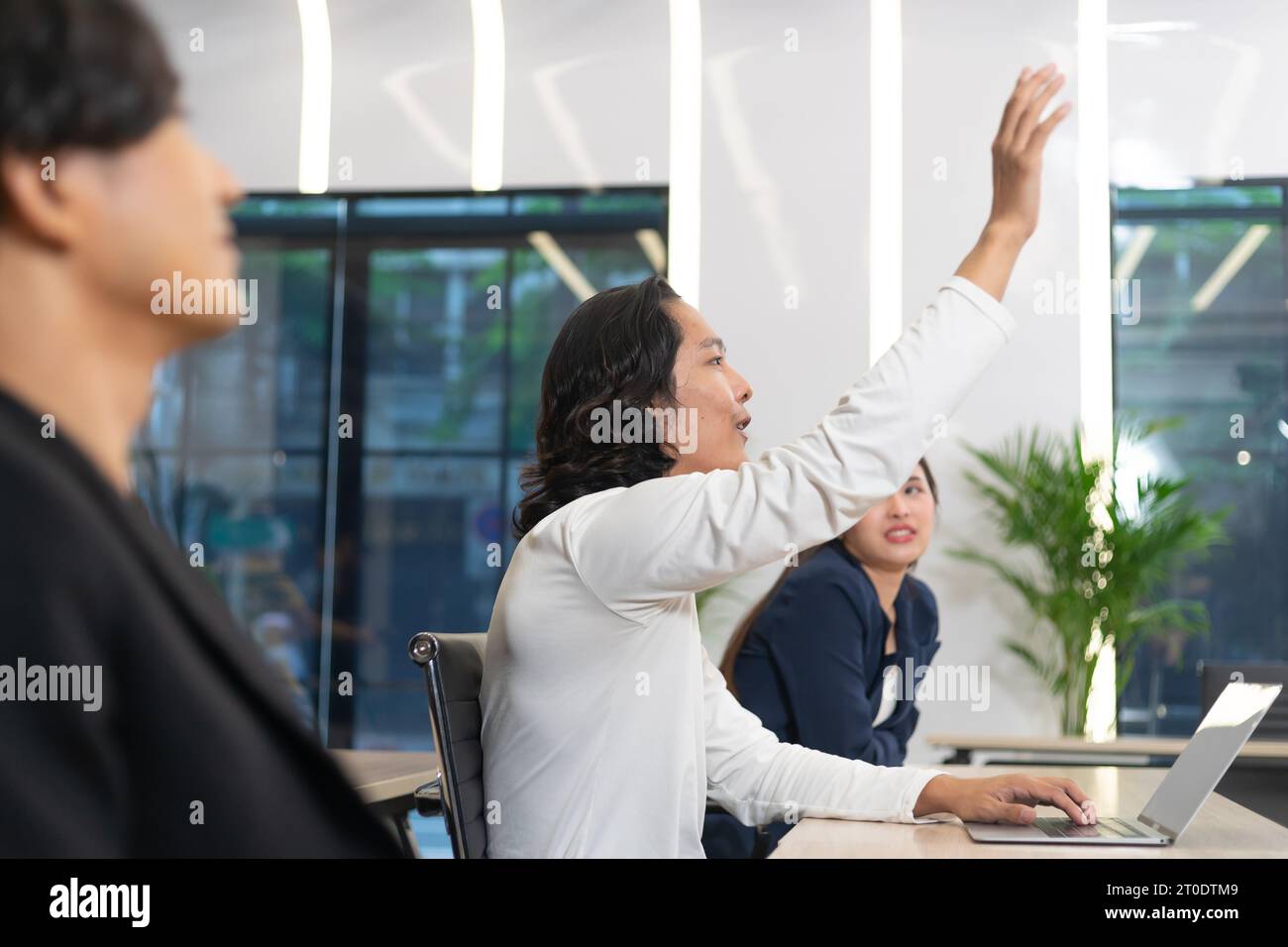Businessman rises hand up for the question in the diverse employees ...
