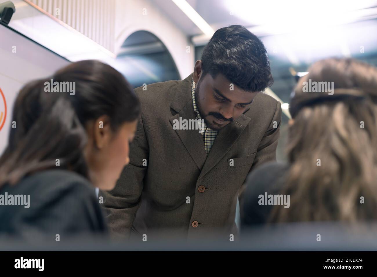 An Indian business boss giving briefs to team worker. Business ...