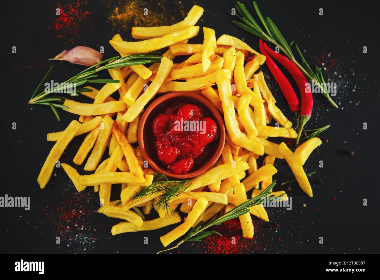 French fries with spices on a black background. Food background, flat ...