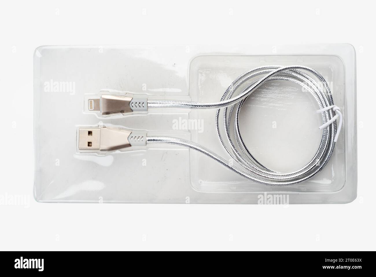 Silver-colored USB cable in plastic packaging on a white background ...