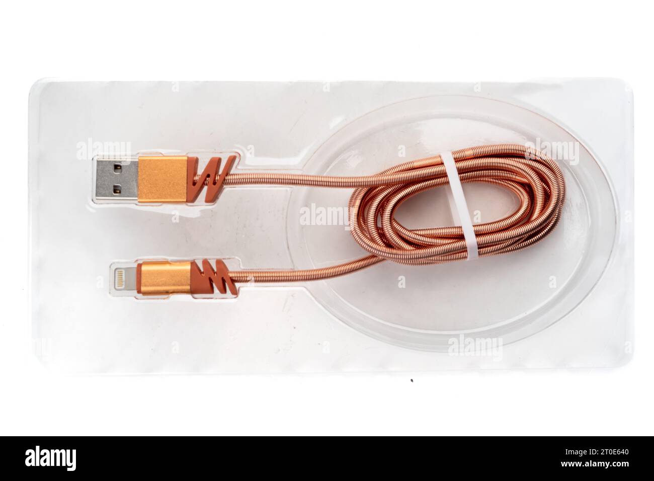 Copper-colored USB cable in plastic packaging on a white background ...