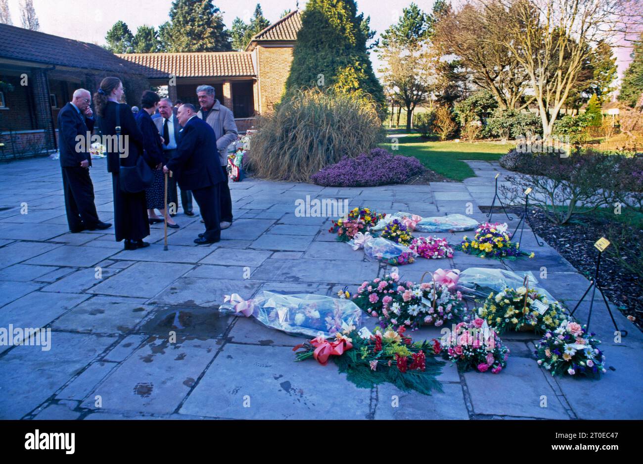 Mourners Talking Outside Crematorium After Cremation Flowers On Ground ... Mourners Talking Outside Crematorium After Cremation Flowers On Ground ...